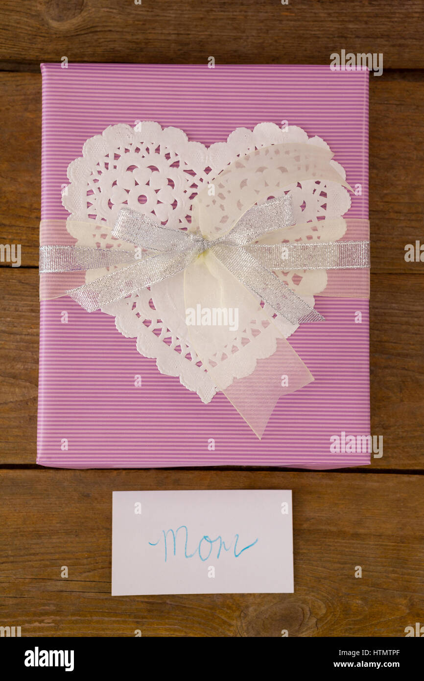 Top view of gift box with mom text on card against wooden background ...