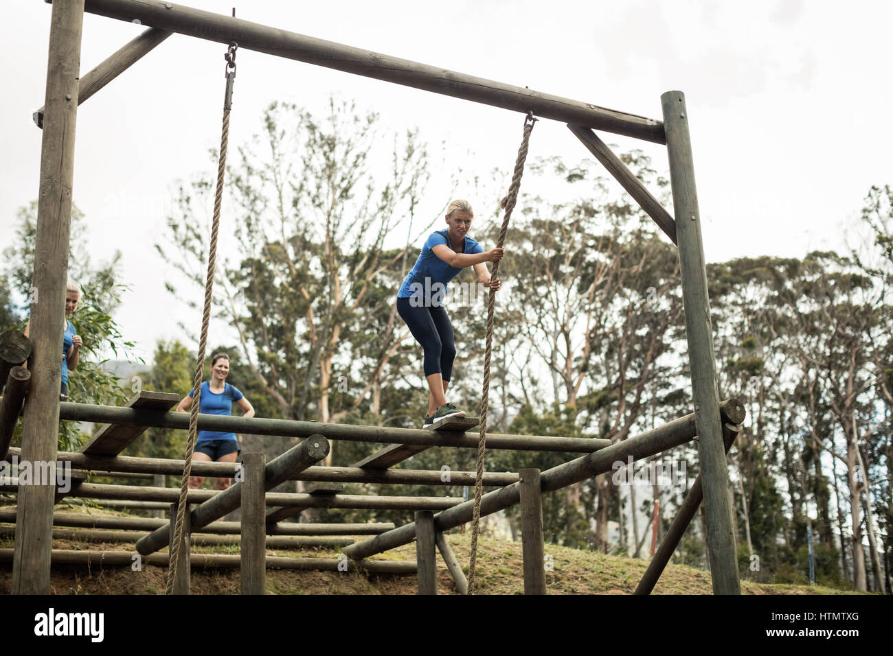 Fit woman holding the rope during obstacle course in boot camp Stock ...
