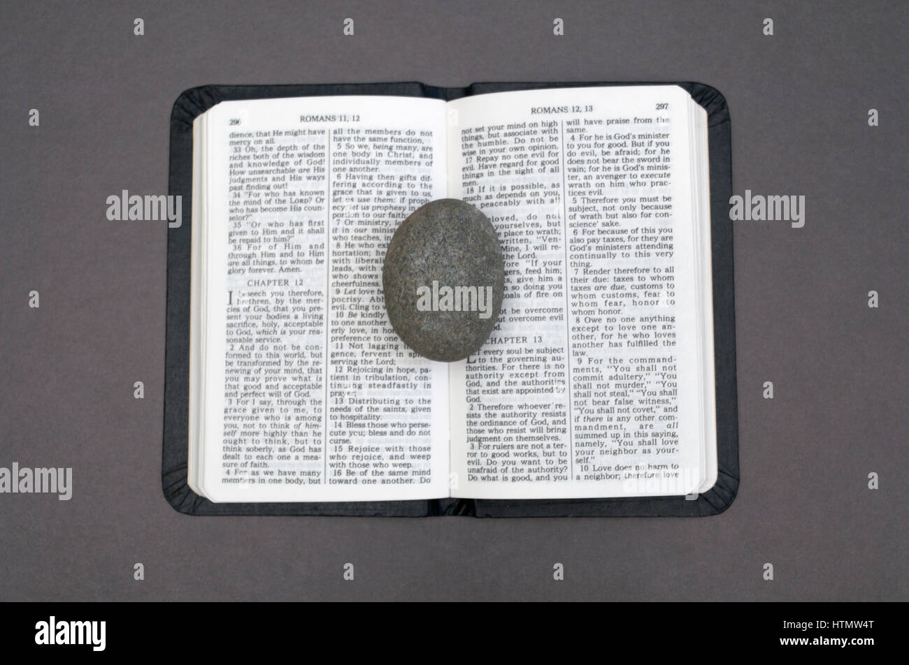 a stone on open bible book Stock Photo - Alamy