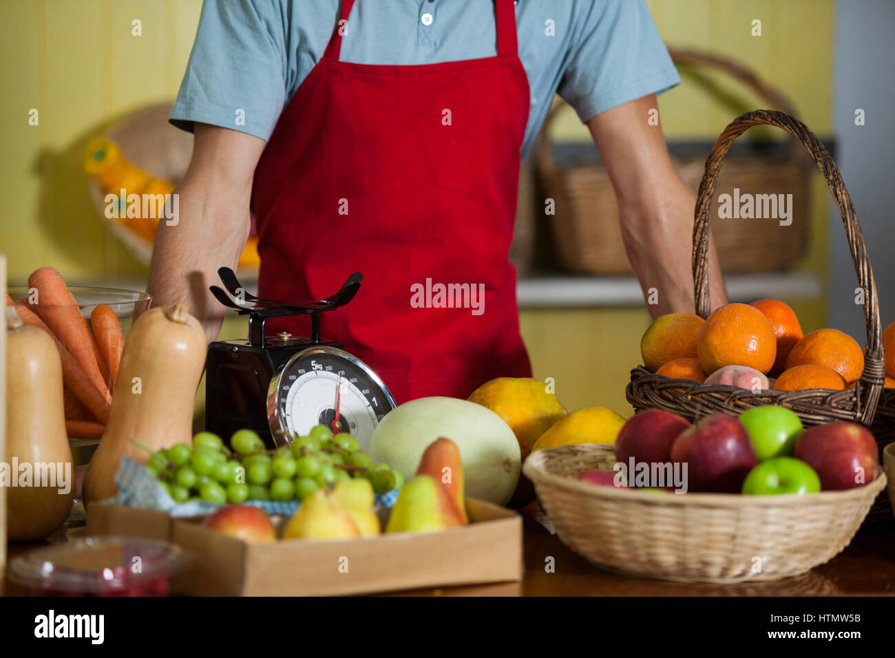 Mid-section of staff standing at counter in market Stock Photo - Alamy