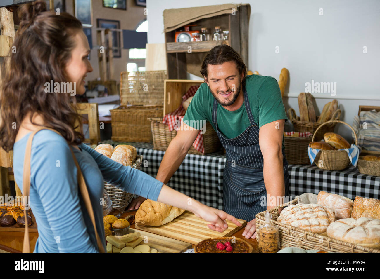 Customer interacting with staff at counter in bakery shop Stock Photo ...