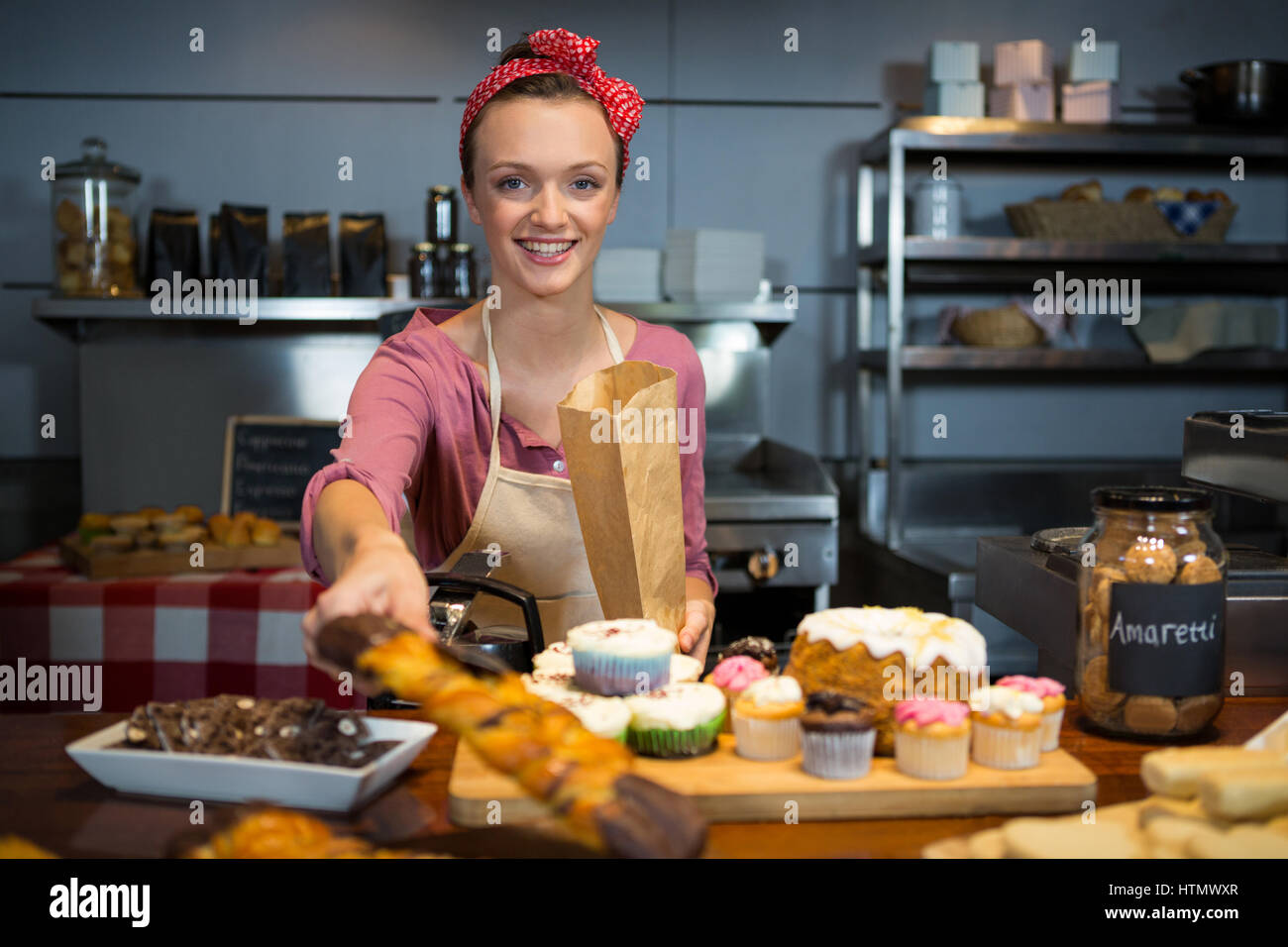 Female staff packing sweet food in paper bag in market Stock Photo - Alamy
