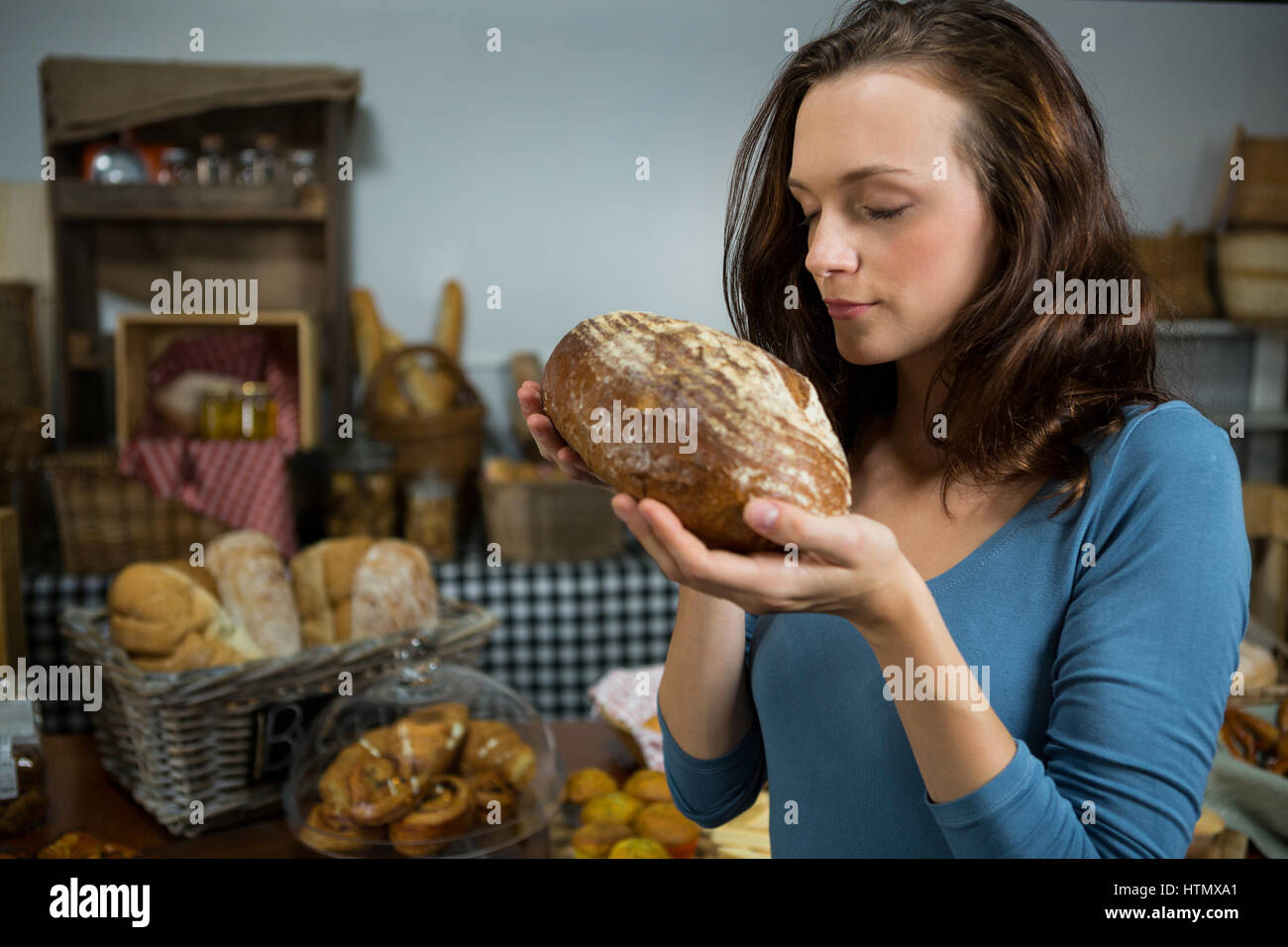 Woman smelling bread at bakery counter in market Stock Photo - Alamy