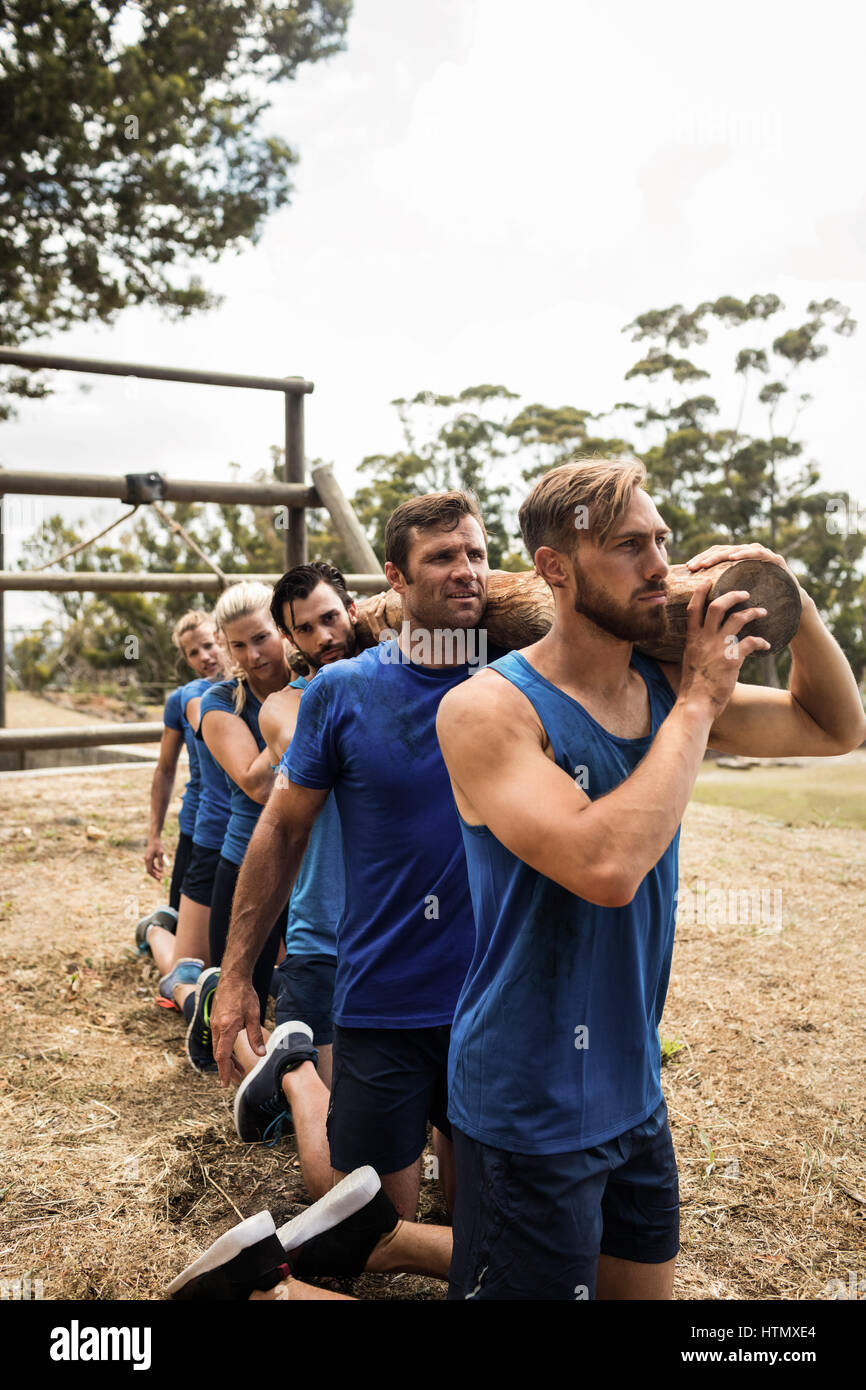 Fit people holding a heavy wooden log during boot camp training Stock ...