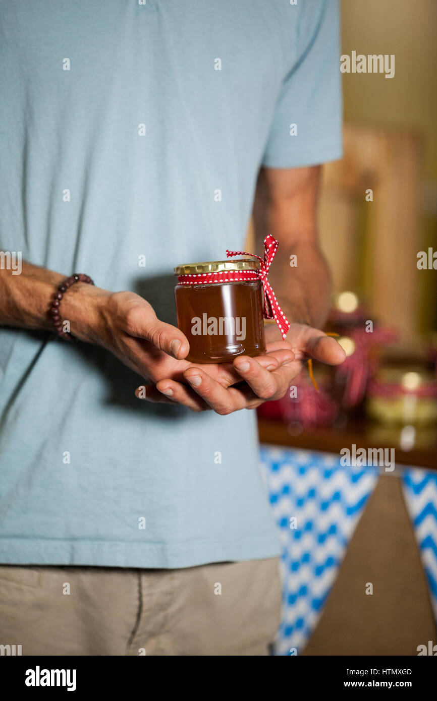 Mid-section of man holding a jar of jam in market Stock Photo - Alamy