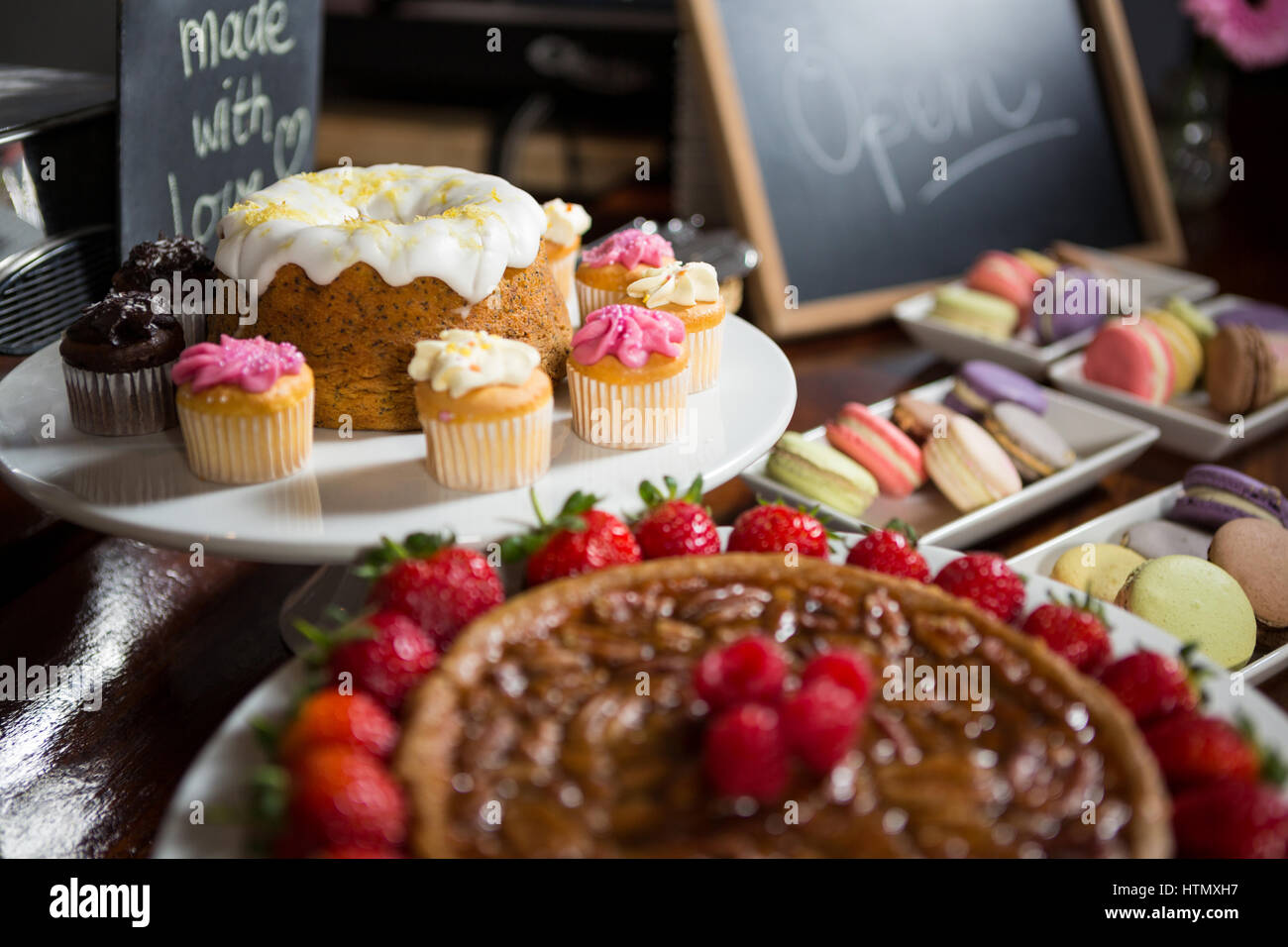 Close-up of strawberry pie and cake at display counter in bakery shop ...