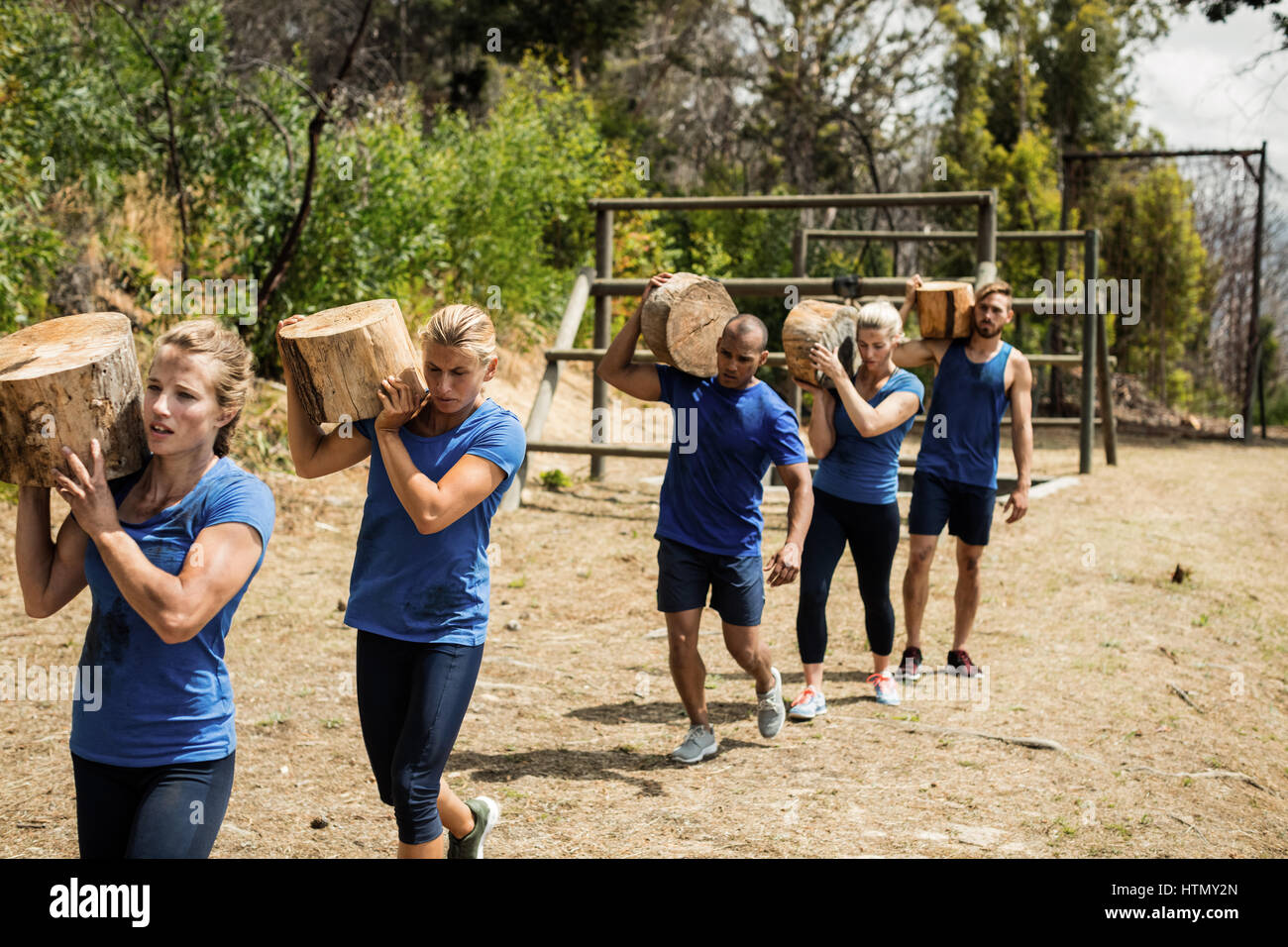 People carrying heavy wooden logs during obstacle course in boot camp ...