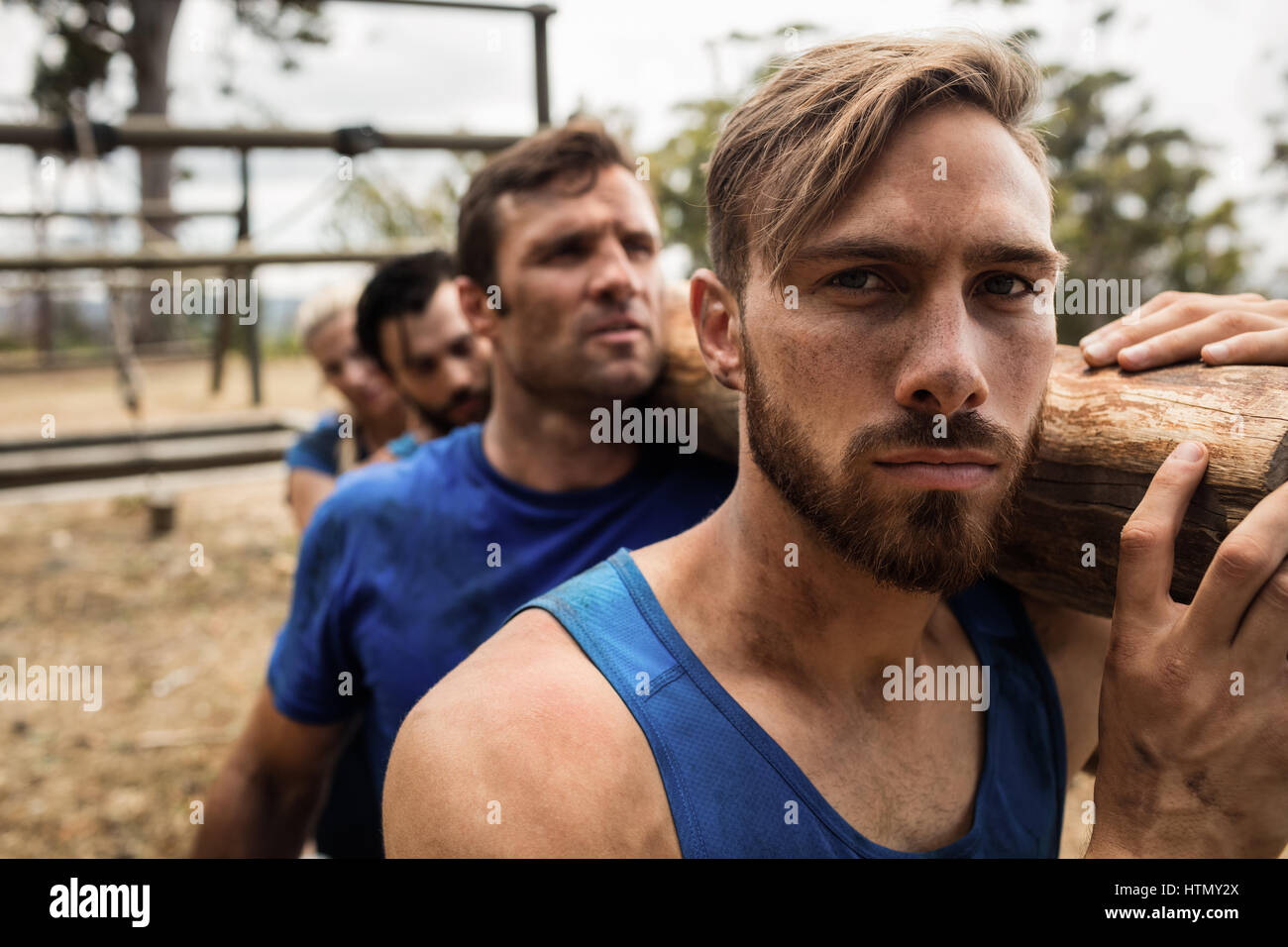 Fit people carrying a heavy wooden log during boot camp training Stock ...