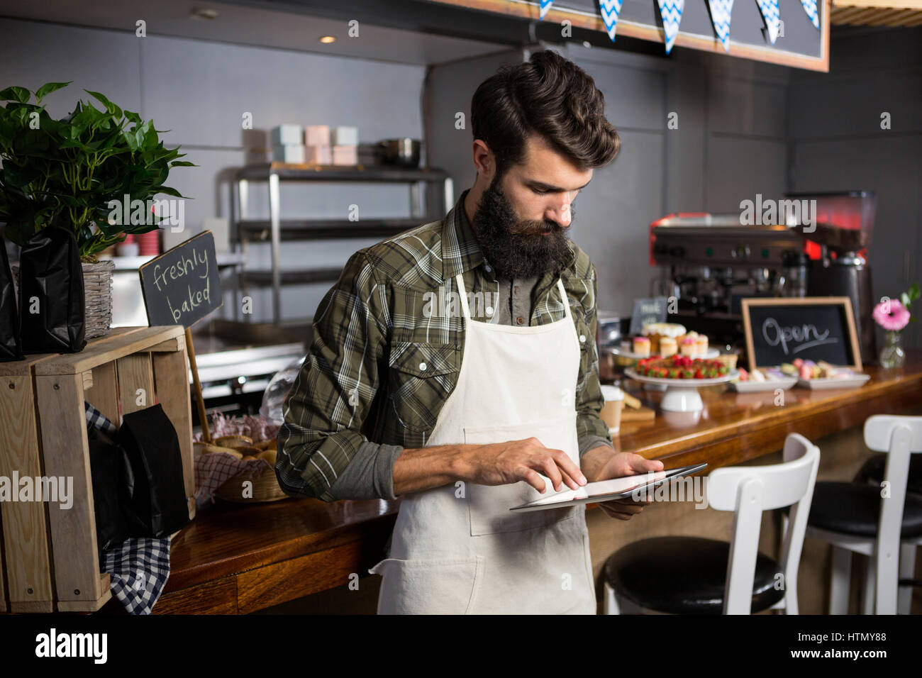 Male staff using digital tablet at counter in coffee shop Stock Photo ...