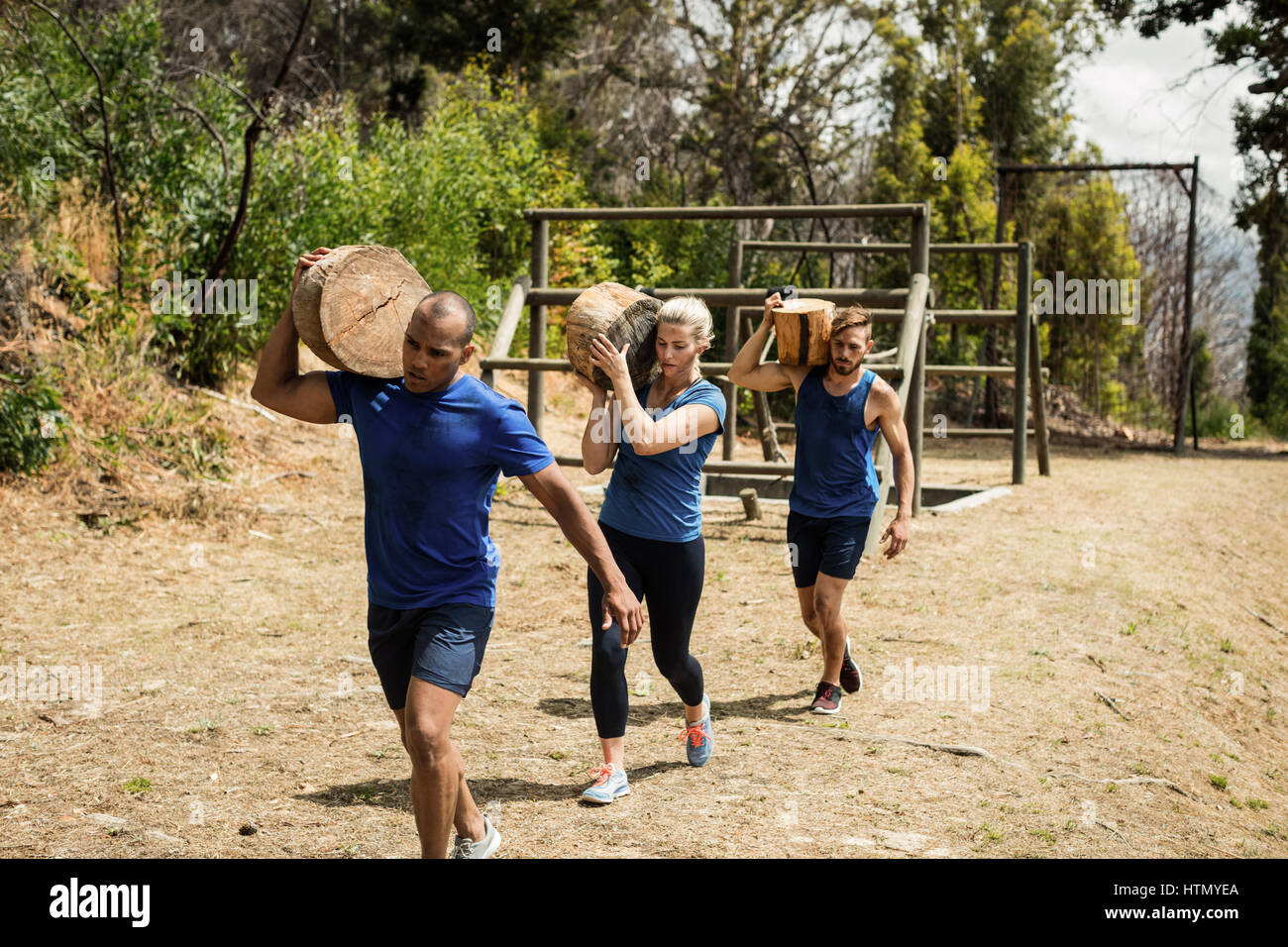People carrying heavy wooden logs during obstacle course in boot camp ...