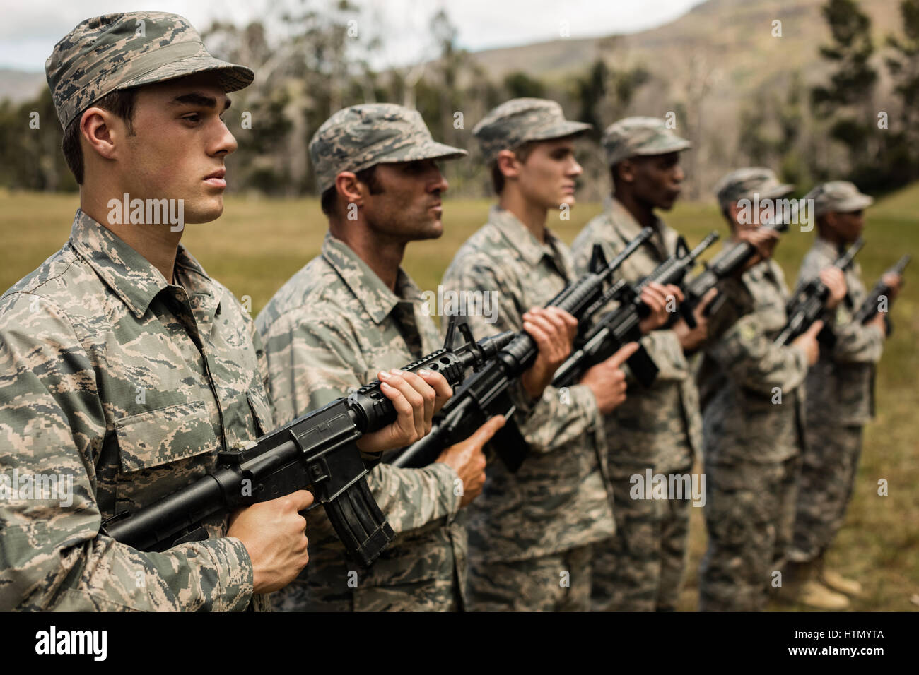 Group of military soldiers standing with rifles at boot camp Stock ...
