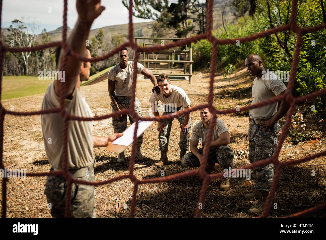 Military soldiers interacting with each other near fitness trial at ...