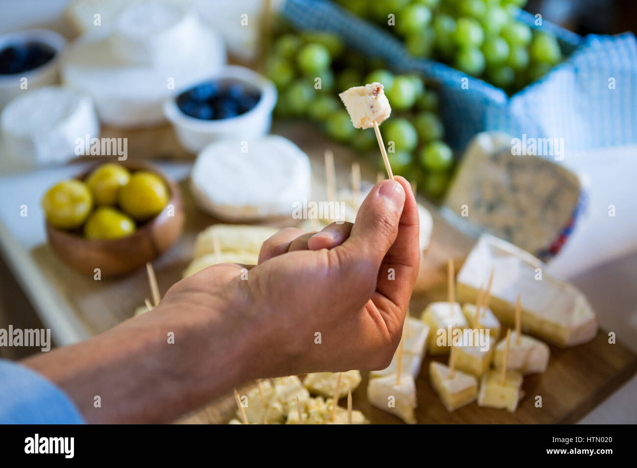 Staff showing a sample of cheese to customer at counter in market Stock ...