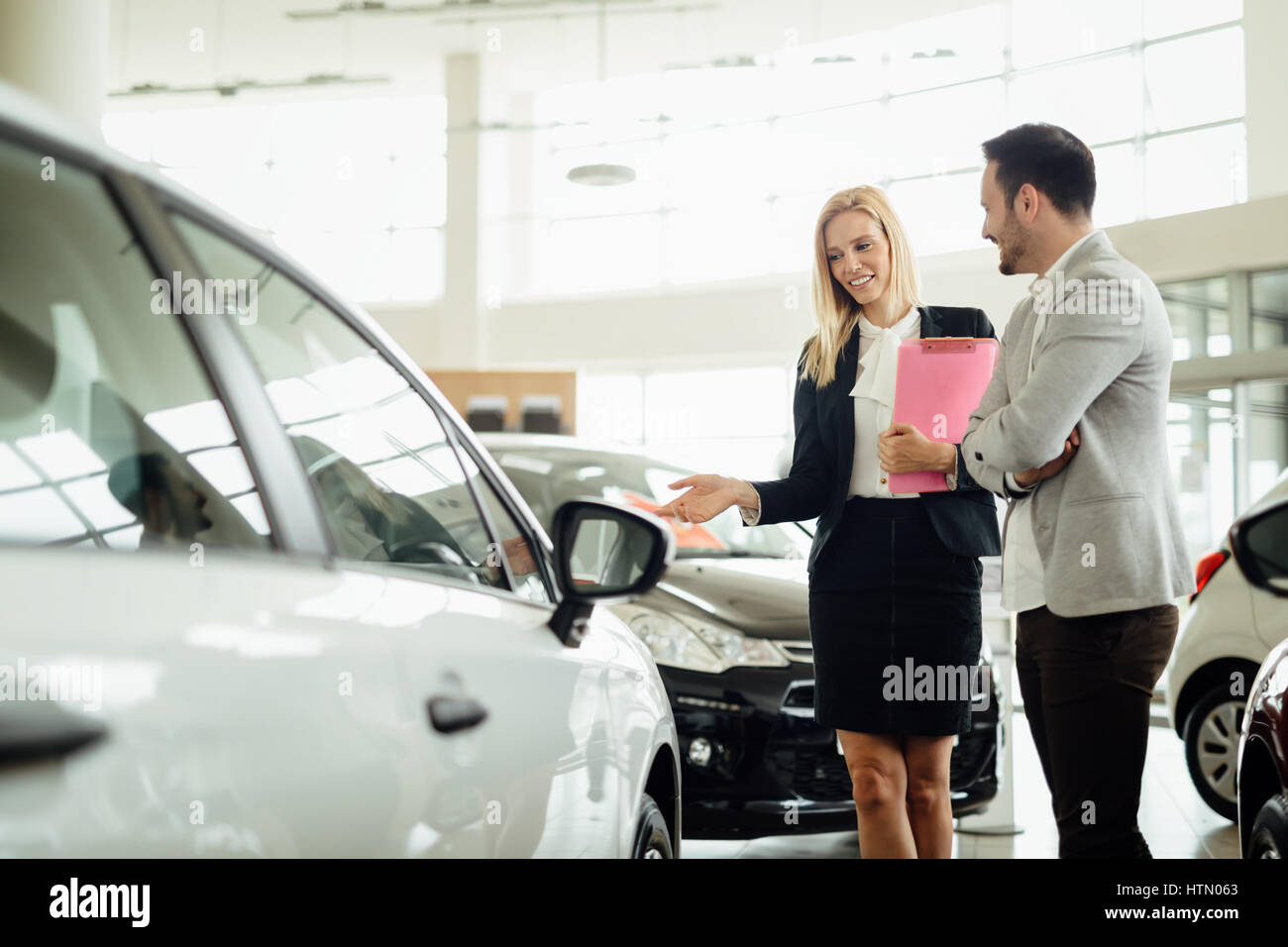 Salesperson selling cars at car dealership Stock Photo - Alamy