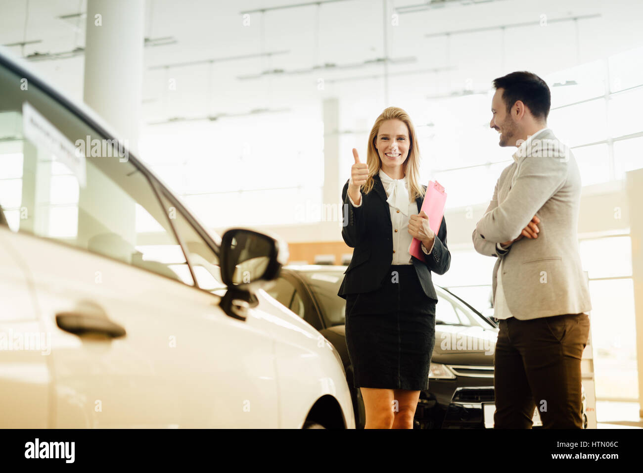 Professional salesperson selling cars at dealership to buyer Stock ...