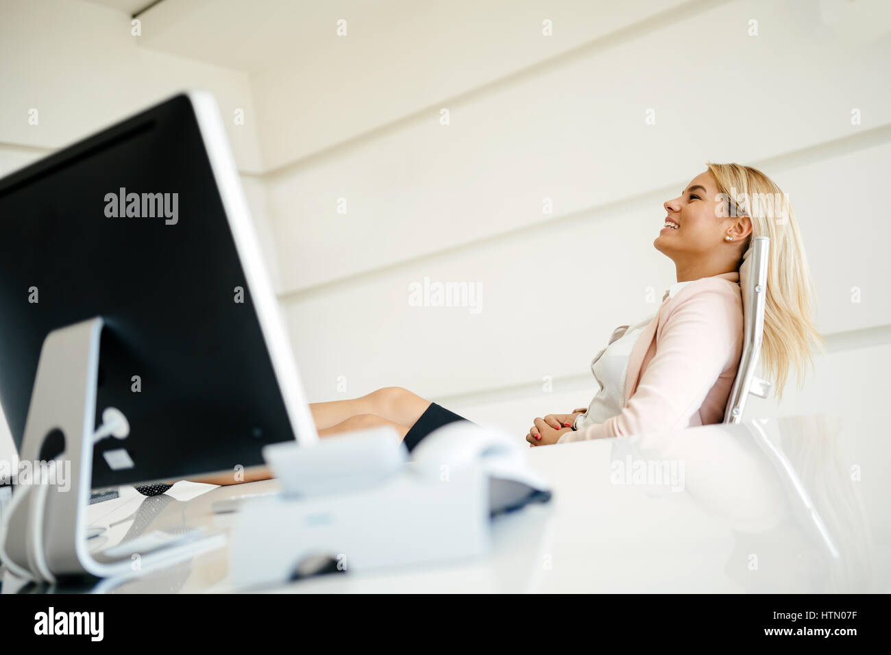Businesswoman taking a break relaxing at desk Stock Photo - Alamy
