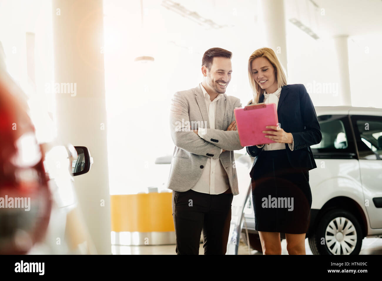 Salesperson selling cars at car dealership Stock Photo - Alamy