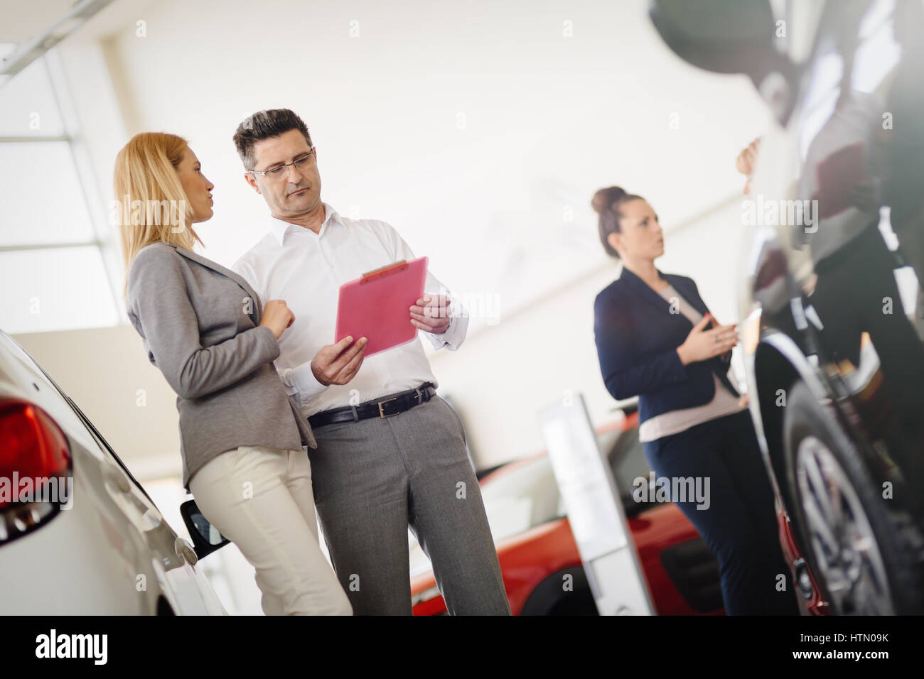 Salesperson selling cars at car dealership Stock Photo - Alamy