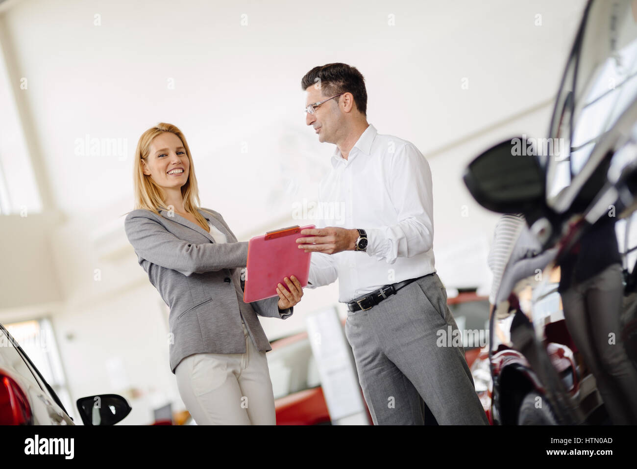 Professional salesperson selling cars at dealership to buyer Stock ...