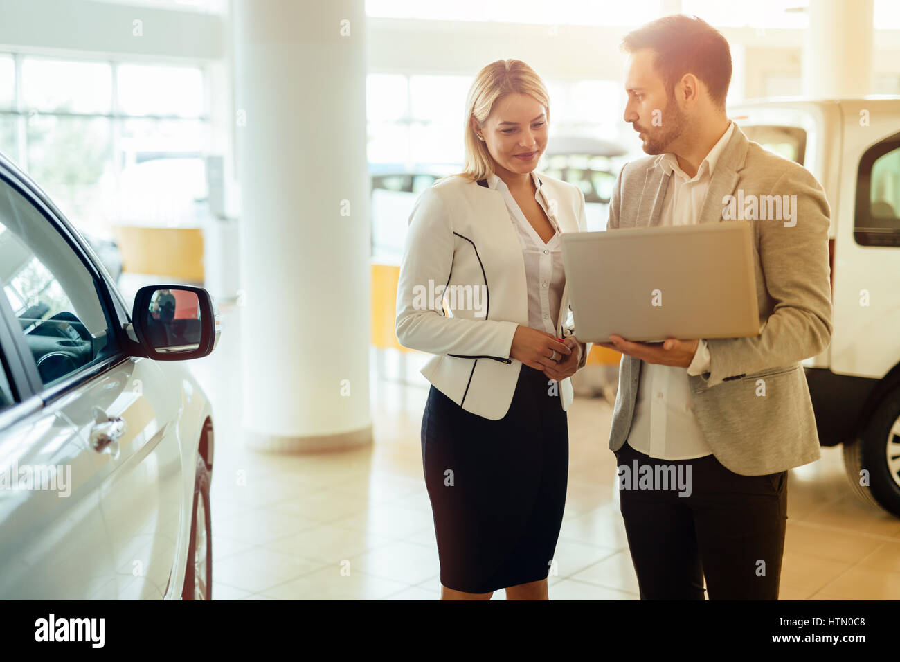 Professional salesperson selling cars at dealership to buyer Stock ...