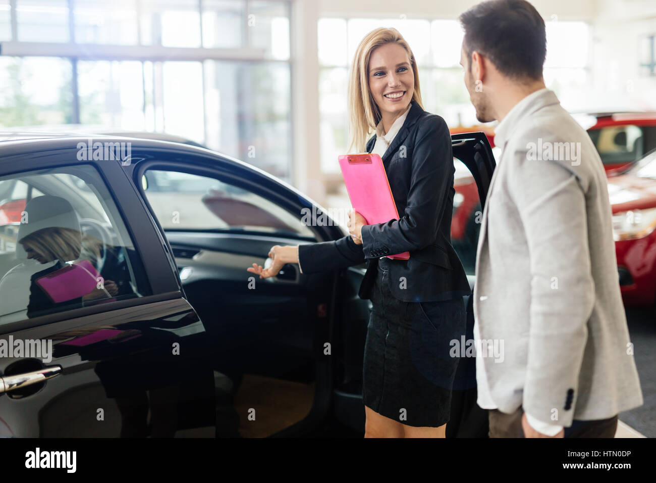 Handsome customer buying car at dealership Stock Photo - Alamy