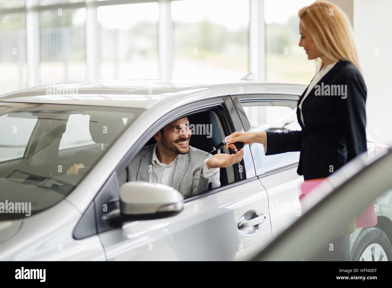 Salesperson selling cars at car dealership Stock Photo - Alamy
