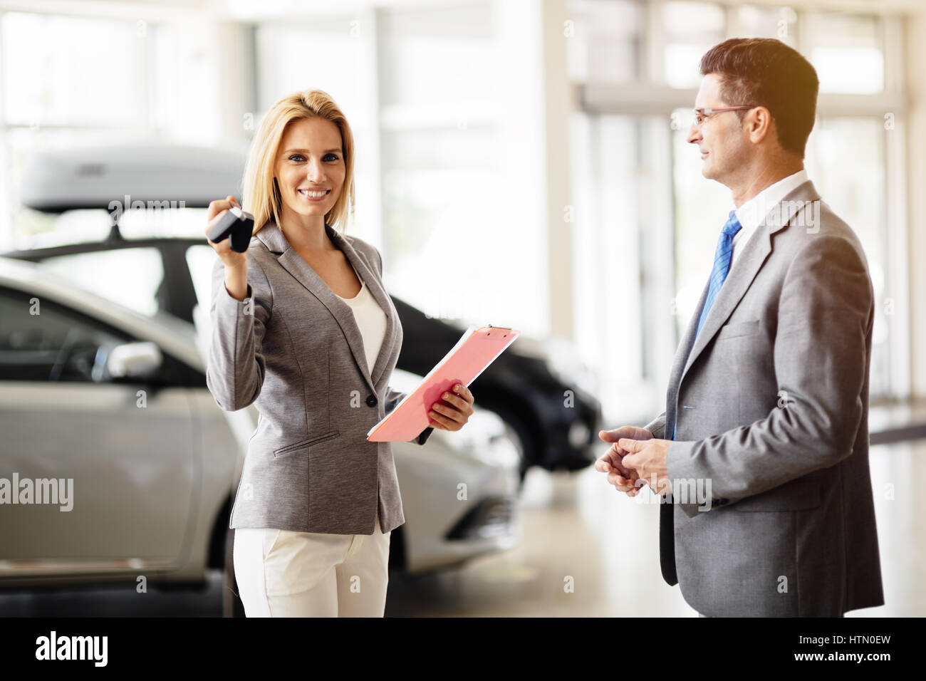 Salesperson selling cars at car dealership Stock Photo - Alamy