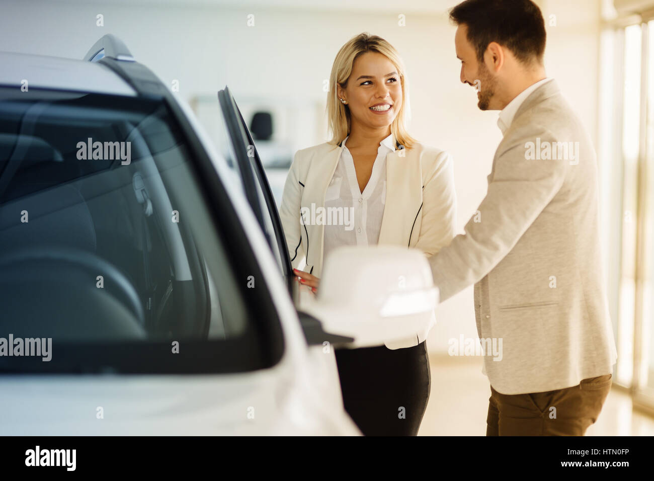 Professional salesperson selling cars at dealership to buyer Stock ...