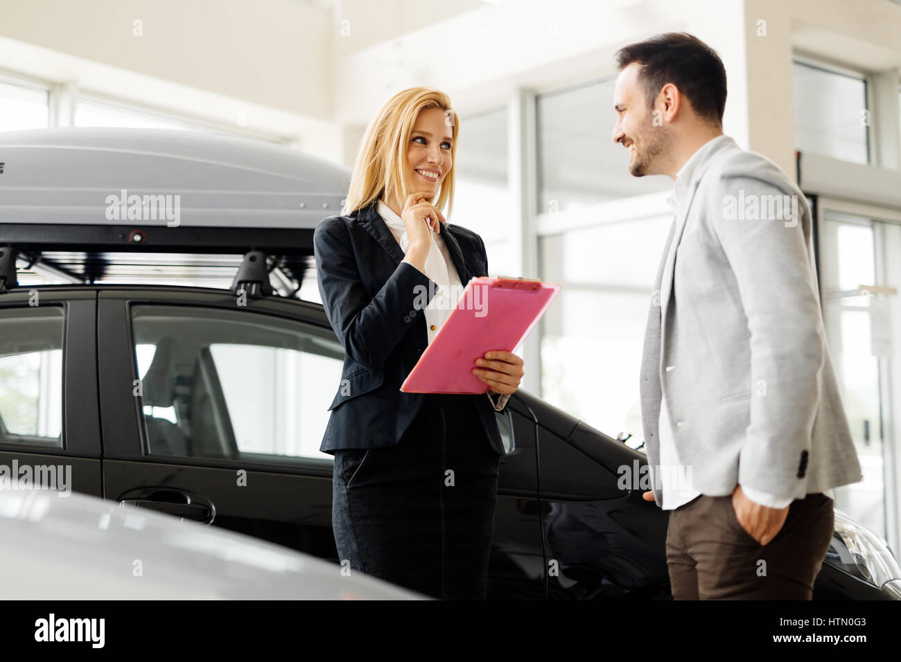 Salesperson selling cars at car dealership Stock Photo - Alamy
