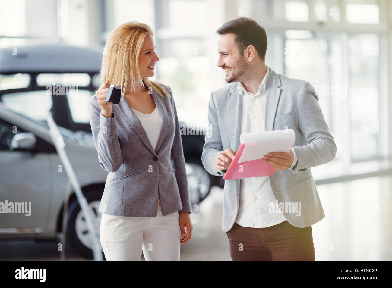 Salesperson selling cars at car dealership Stock Photo - Alamy