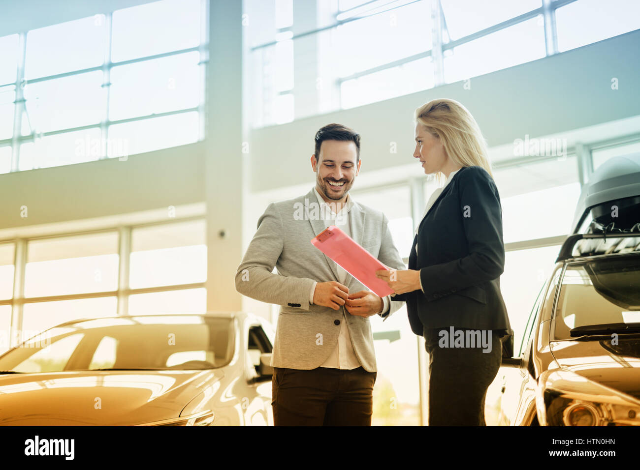 Salesperson selling cars at car dealership Stock Photo - Alamy