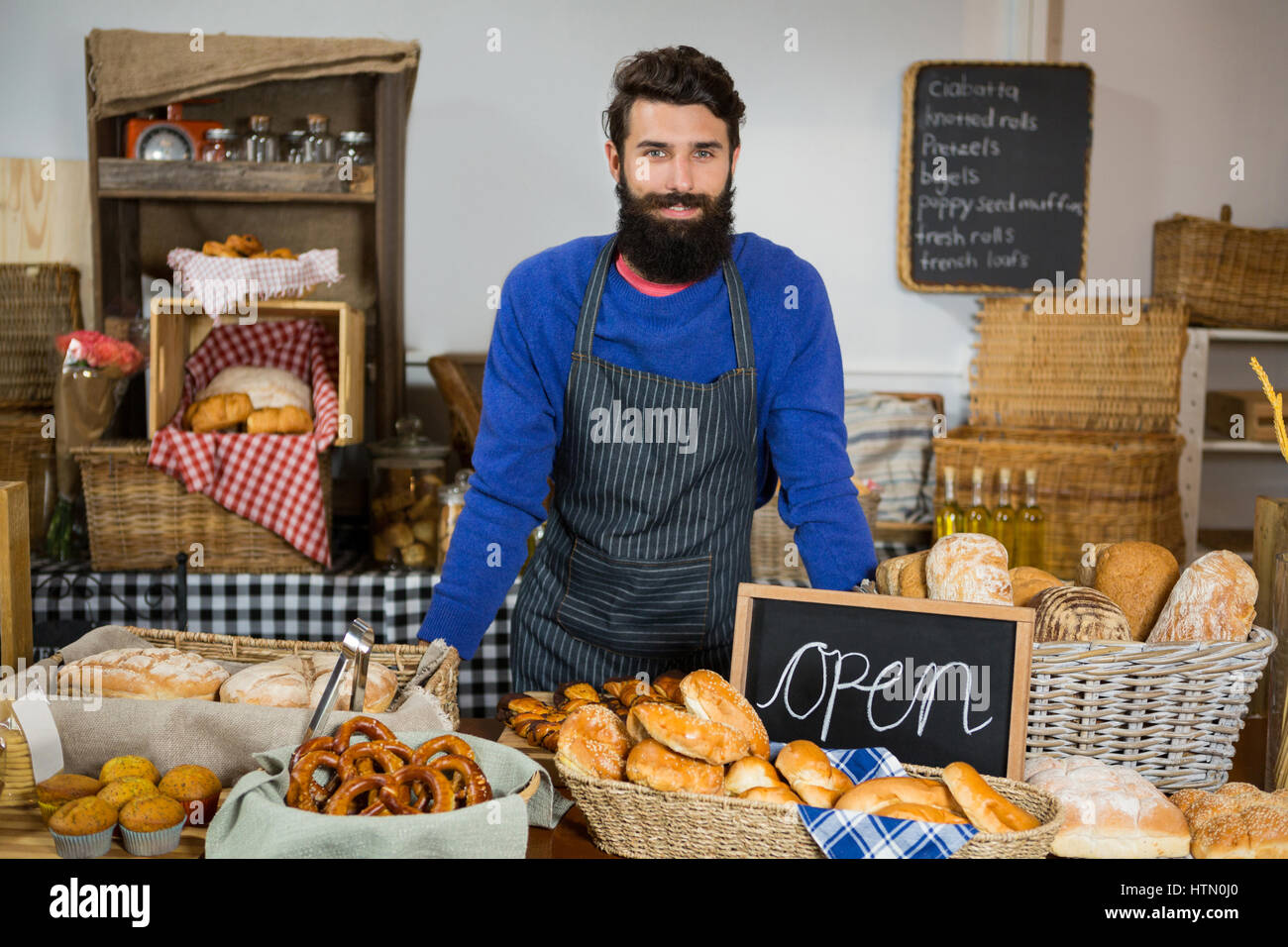 Portrait of smiling male staff standing at counter in bakery shop Stock ...