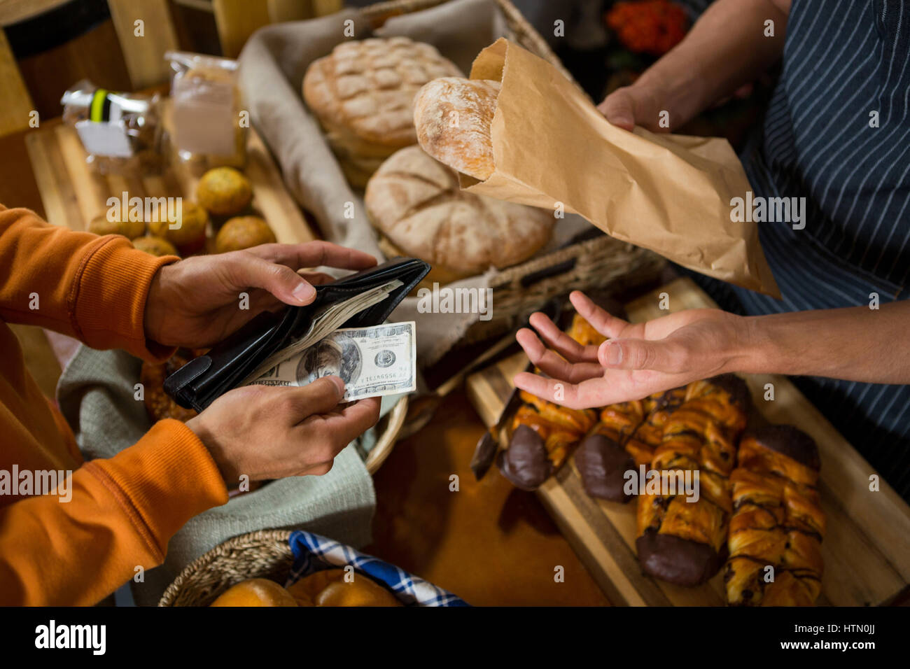 Customer paying bill by cash at bread counter in bakery shop Stock ...