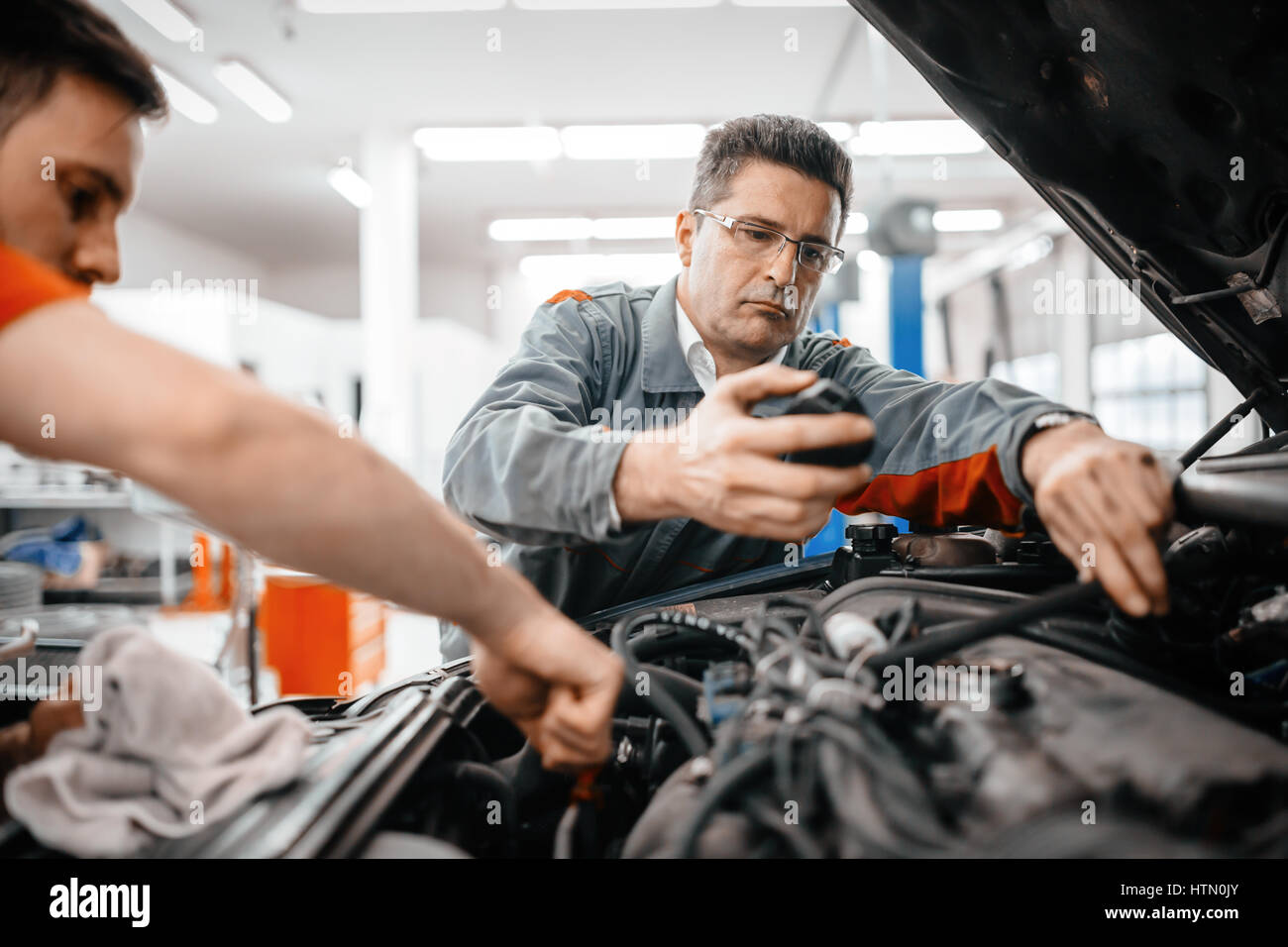 Car mechanics working on car maintenance Stock Photo - Alamy