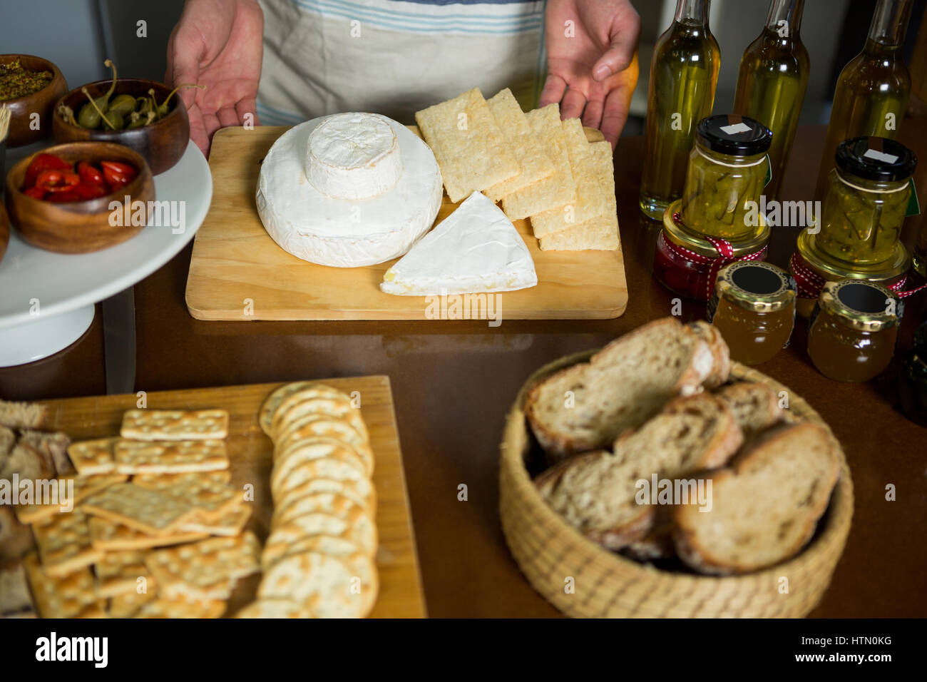 Staff standing near various cheeses at counter in grocery shop Stock ...