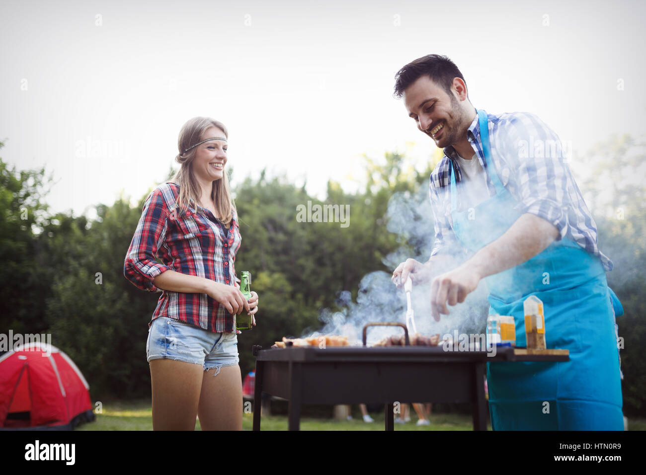 Friends having fun grilling meat enjoying bbq party Stock Photo - Alamy
