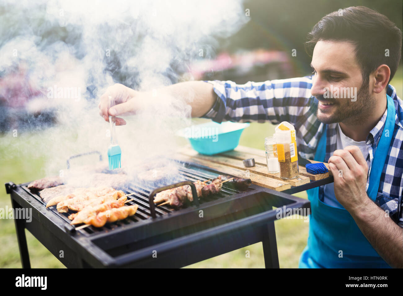 Handsome male grilling meat for barbecue party outdoor Stock Photo - Alamy