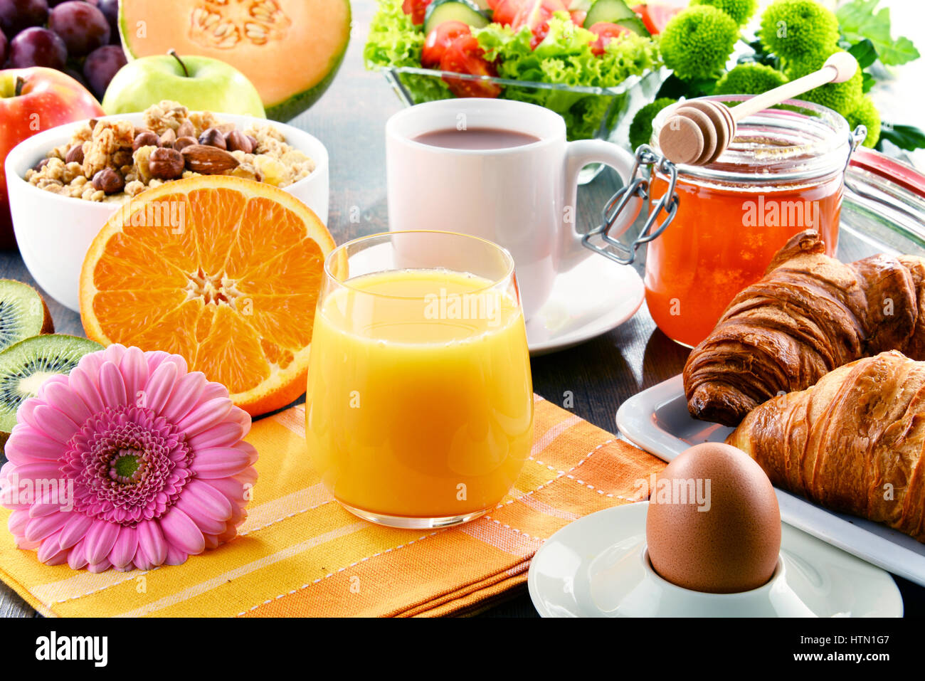 Breakfast consisting of fruits, orange juice, coffee, honey, bread and ...