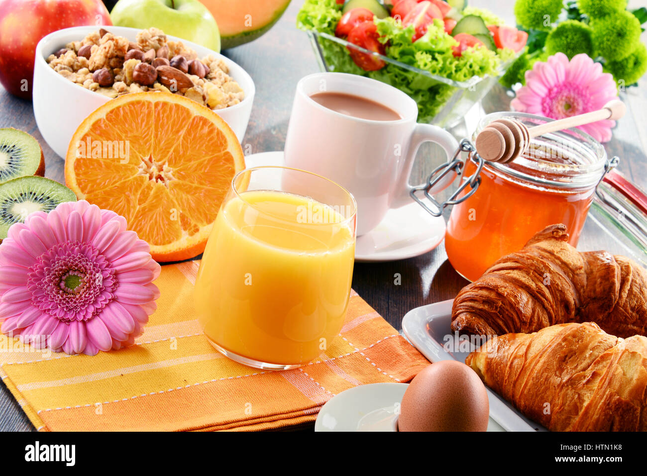 Breakfast consisting of fruits, orange juice, coffee, honey, bread and ...