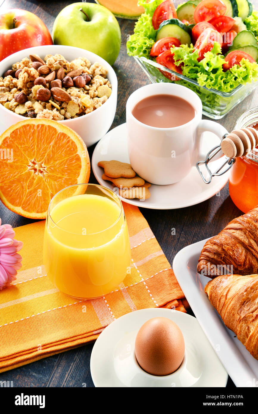 Breakfast consisting of fruits, orange juice, coffee, honey, bread and ...
