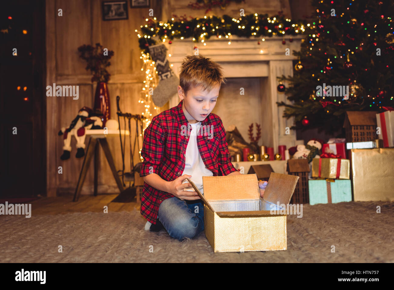 Boy opening christmas present Stock Photo - Alamy