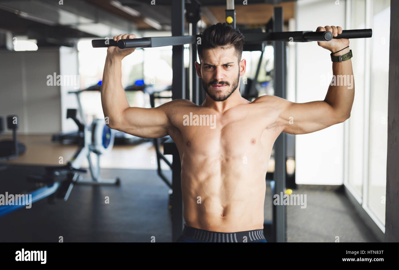 Man working out in gym on fitness machine Stock Photo - Alamy