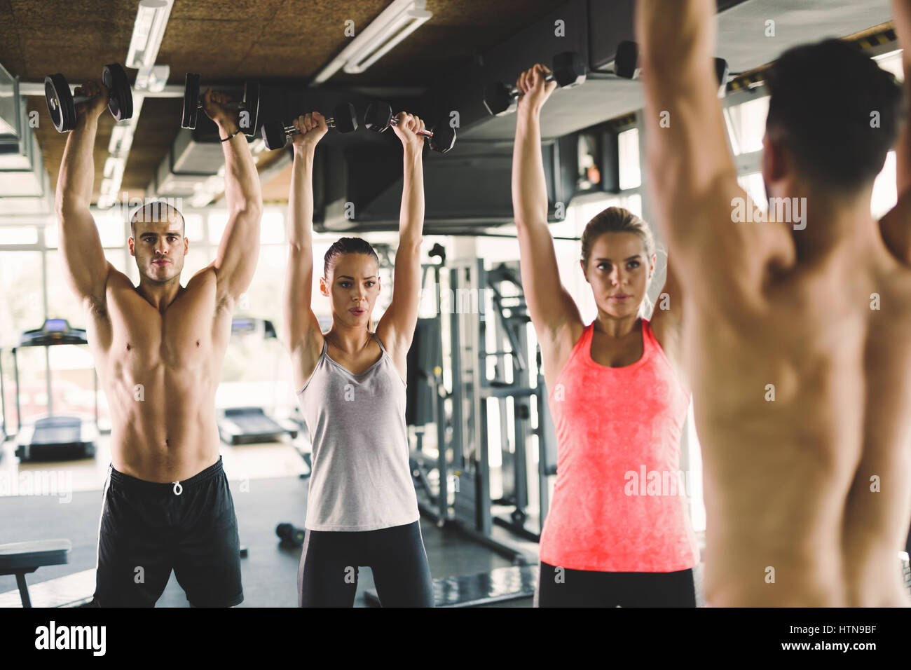 People working out at fitness training together in gym Stock Photo - Alamy