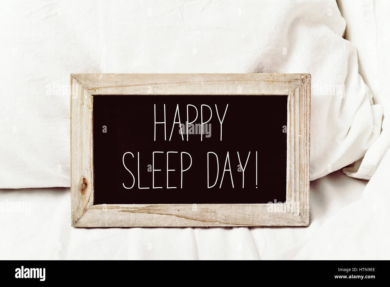 closeup of a wooden-framed chalkboard with the text happy sleep day ...
