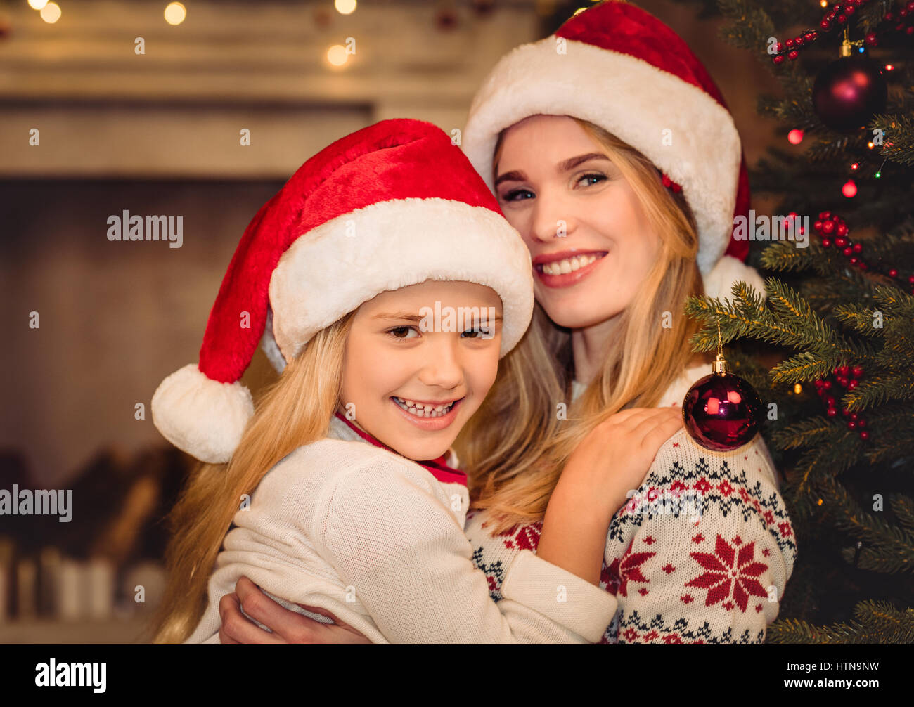 Happy mother and daughter in santa hats Stock Photo - Alamy