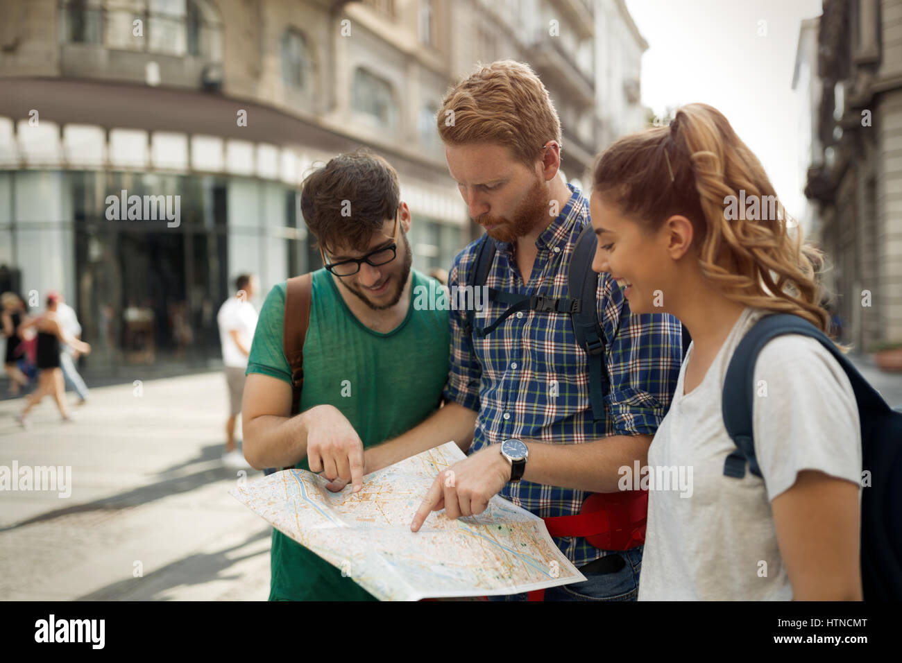 Young happy tourists holding map sightseeing in city Stock Photo - Alamy