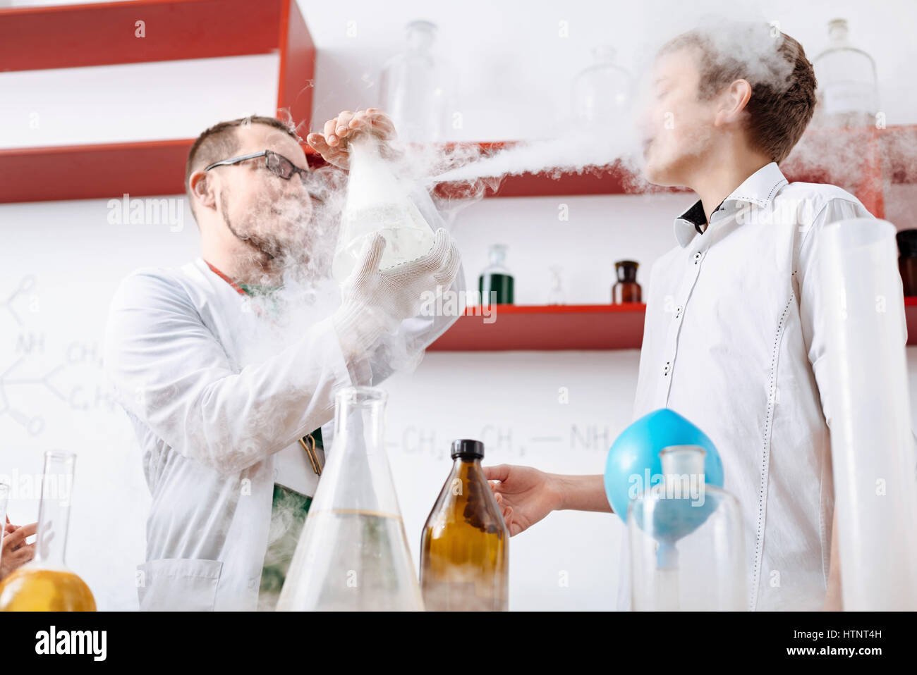 Strong reaction. Nice pleasant male chemist standing near the table and ...