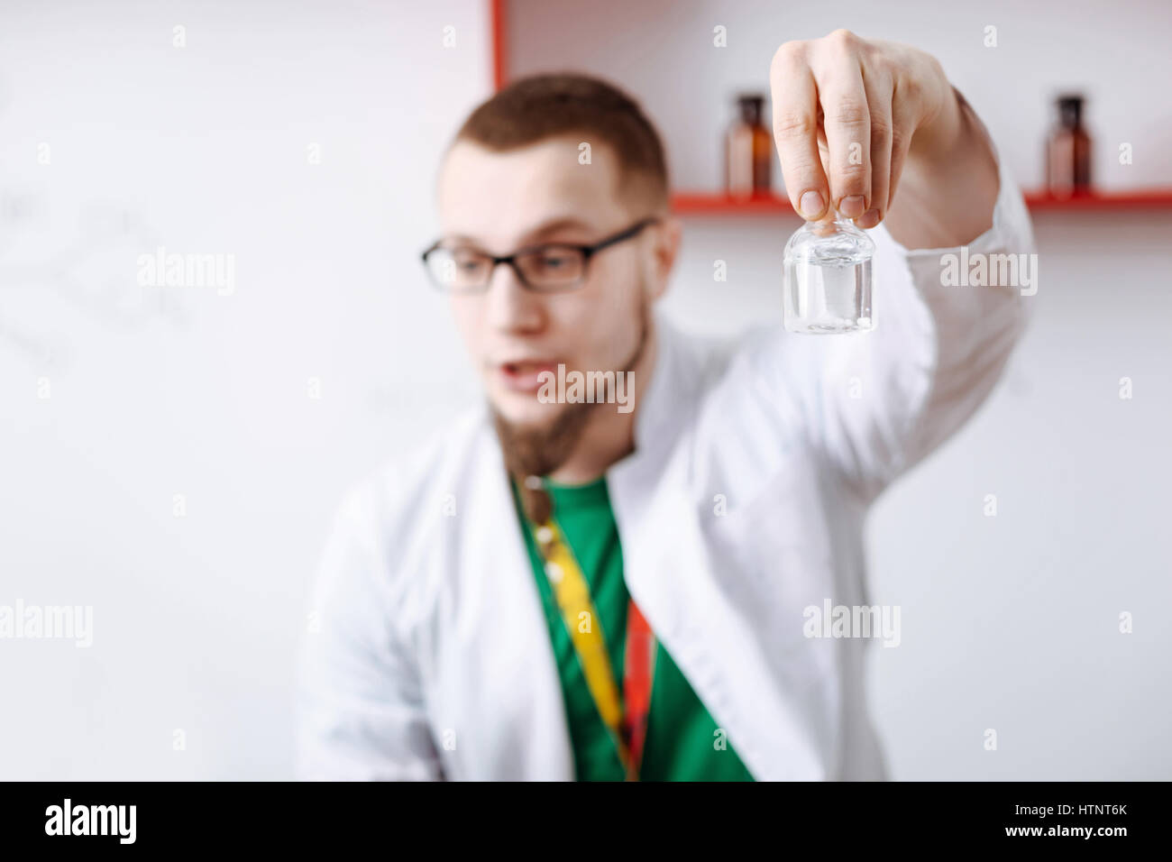 Dangerous chemical liquid. Nice handsome male scientist wearing a white ...