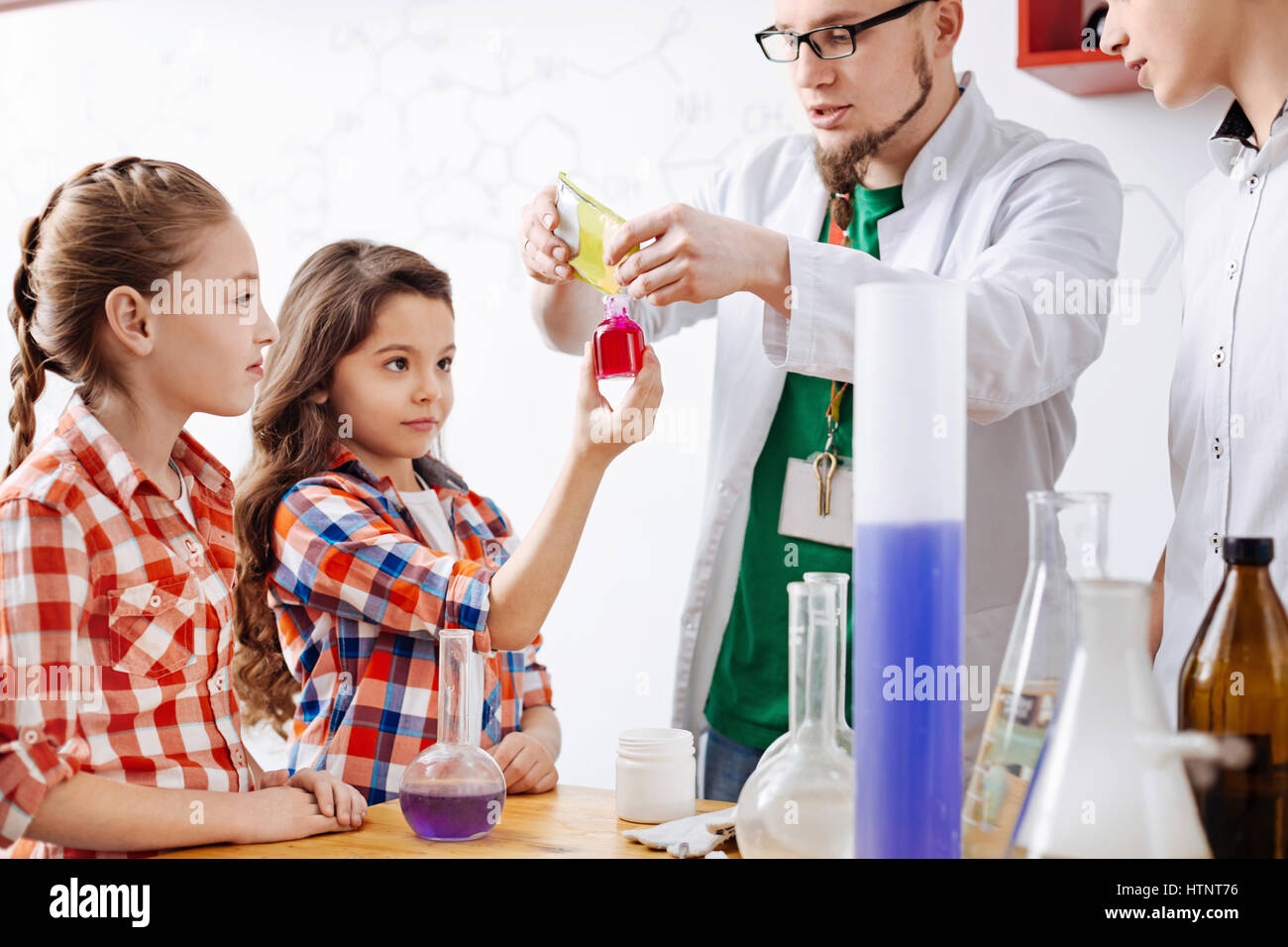 Helping with an experiment. Nice cute delighted girl holding a bottle ...