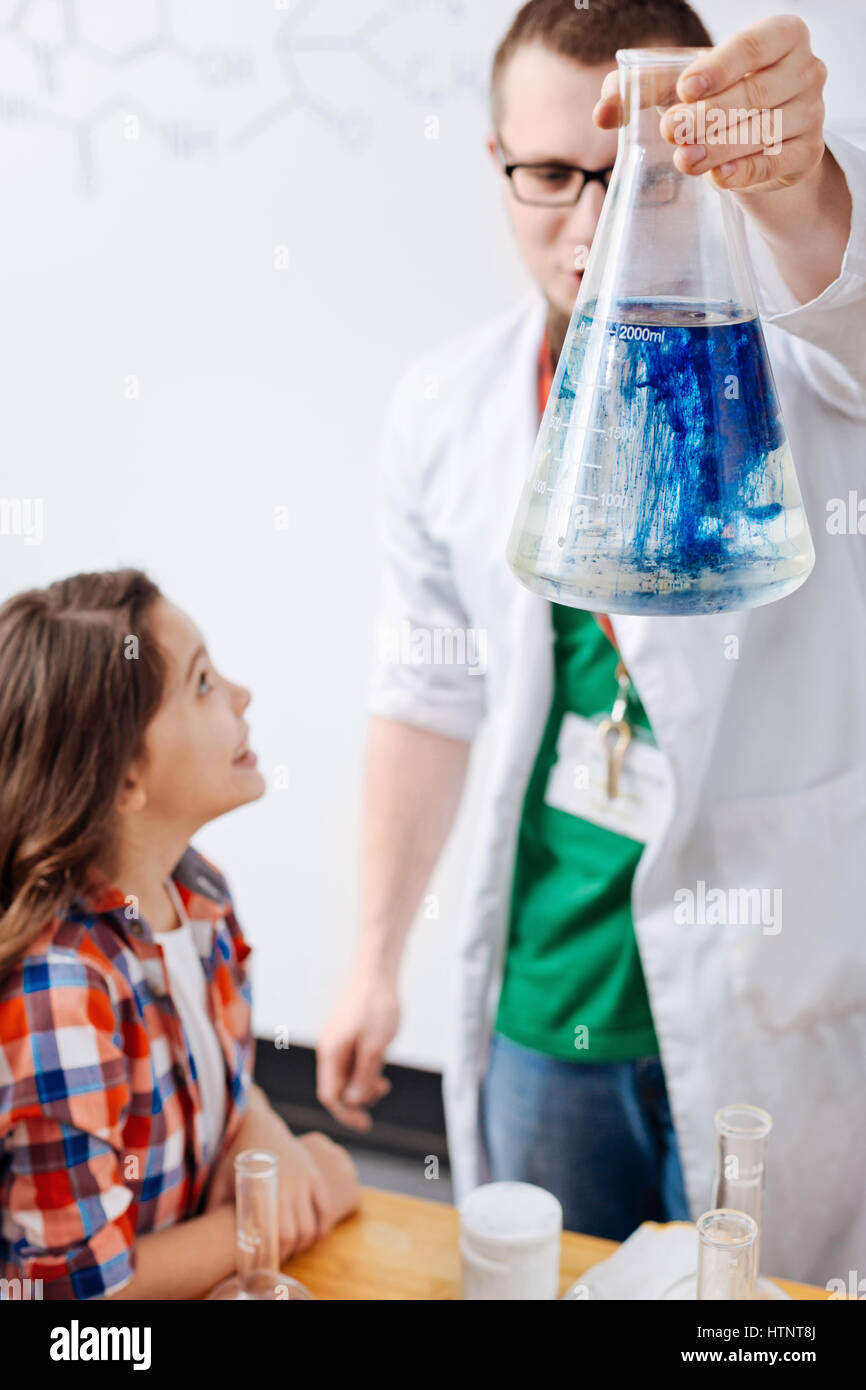 Magic of science. Professional smart male scientist holding a chemical ...